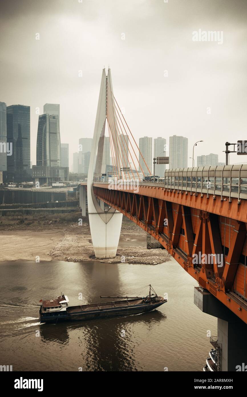 Boat pass below bridge with city urban architecture in Chongqing, China ...