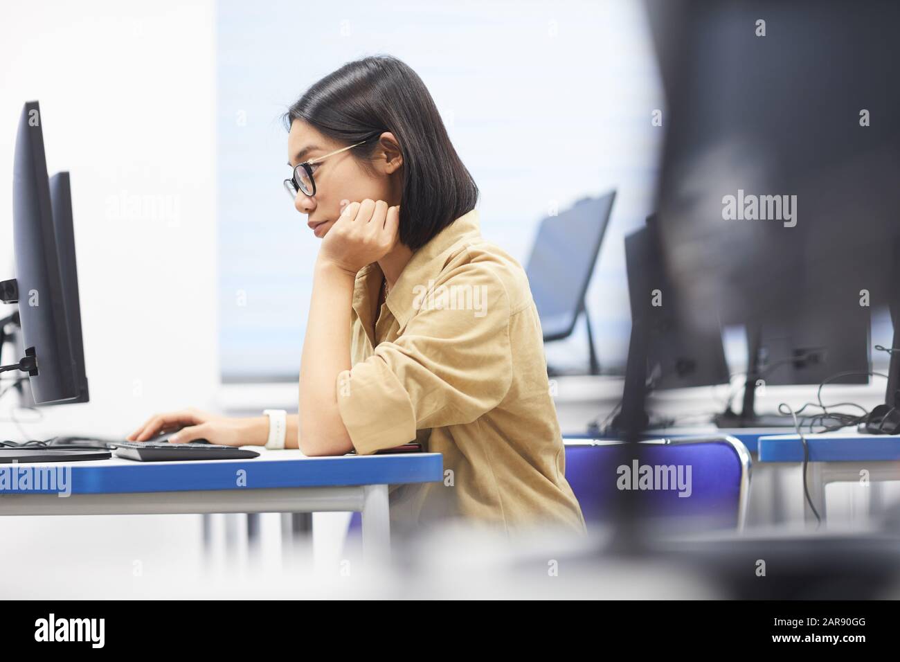 Side view portrait of young Asian woman using computer in class of ...