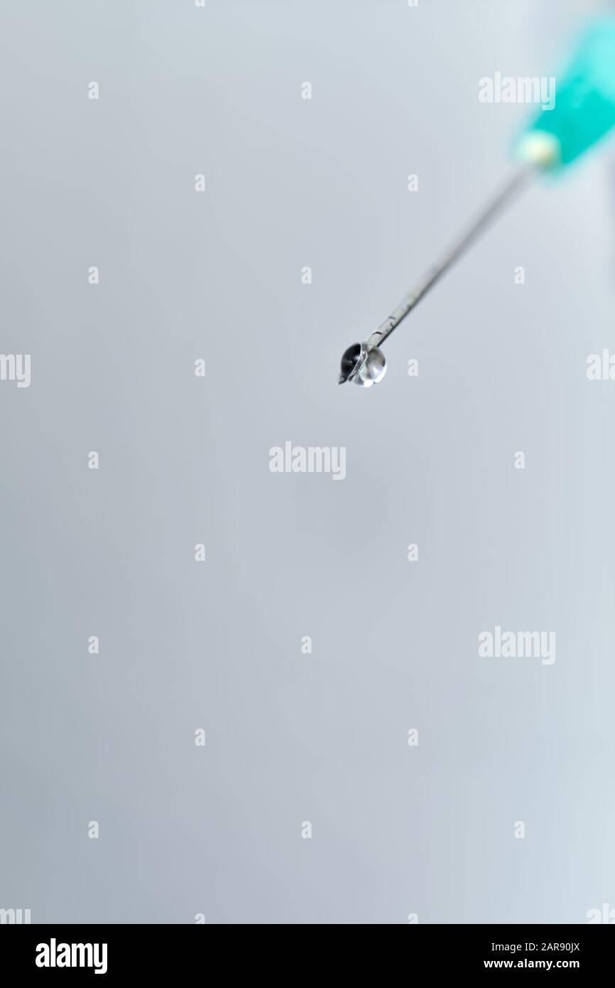 macro photo of the tip of an injection needle with a drop of medicine ...