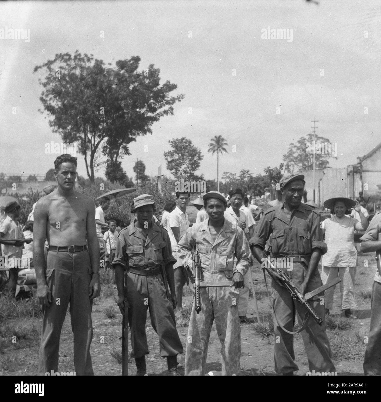 [four KNIL soldiers, two armed with machine guns] Annotation: Machine ...