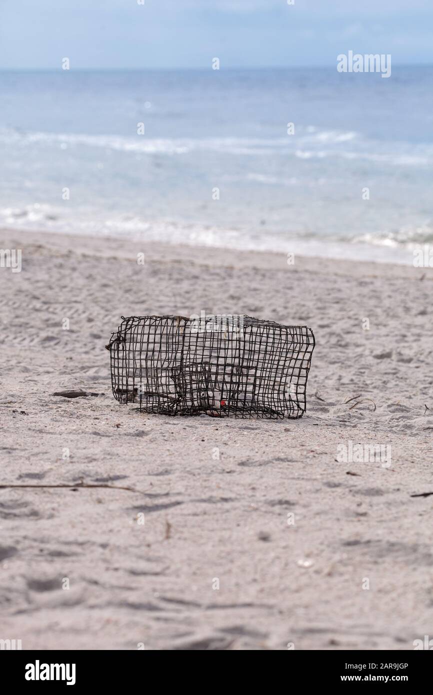 Crab and lobster trap washed up on the white sand beach of Tigertail ...