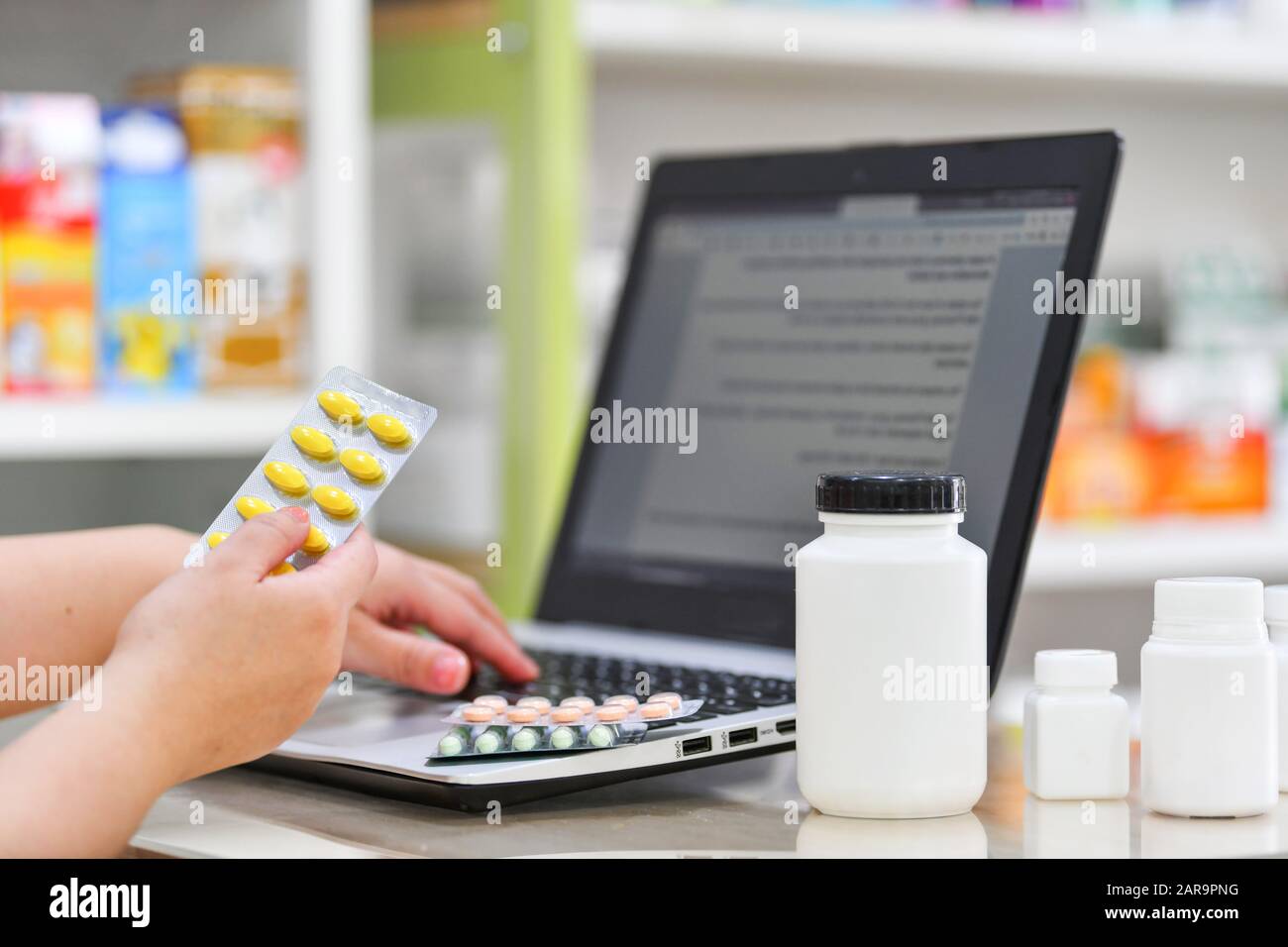 Pharmacist using the computer laptop in chemist shop or pharmacy drug ...