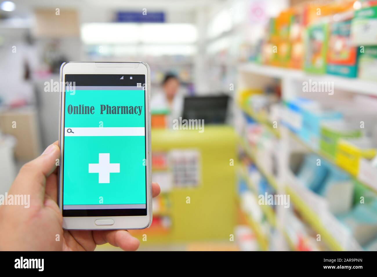 Pharmacist using mobile smart phone for search bar on display in ...