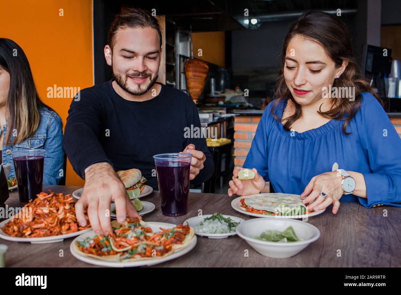 Mexican people eating Tacos al Pastor in a Taqueria in Mexico city ...