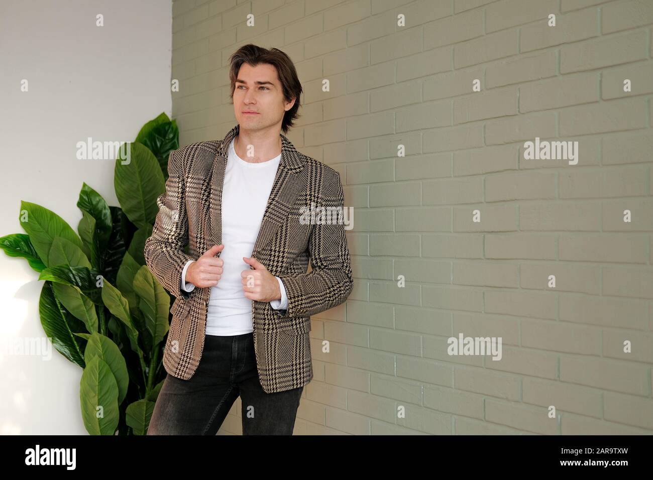 Tall handsome man standing next to grey wall Stock Photo - Alamy