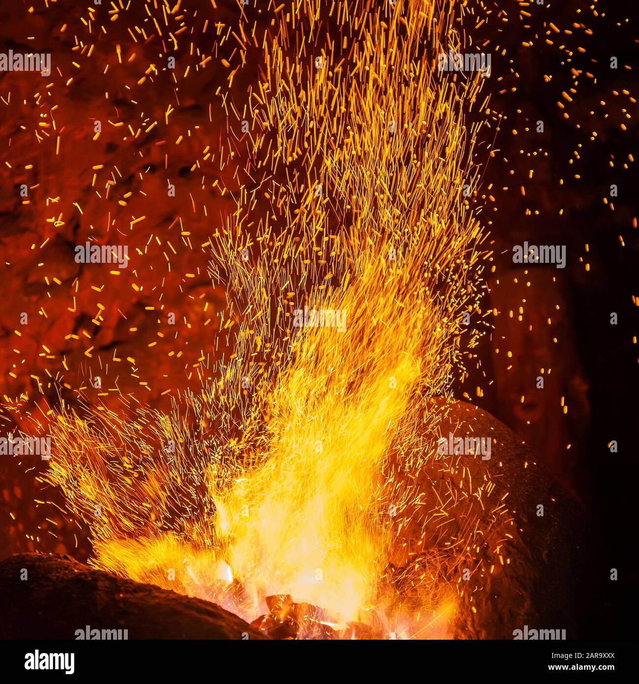Burning red hot sparks fly from big fire. Abstract dark background ...