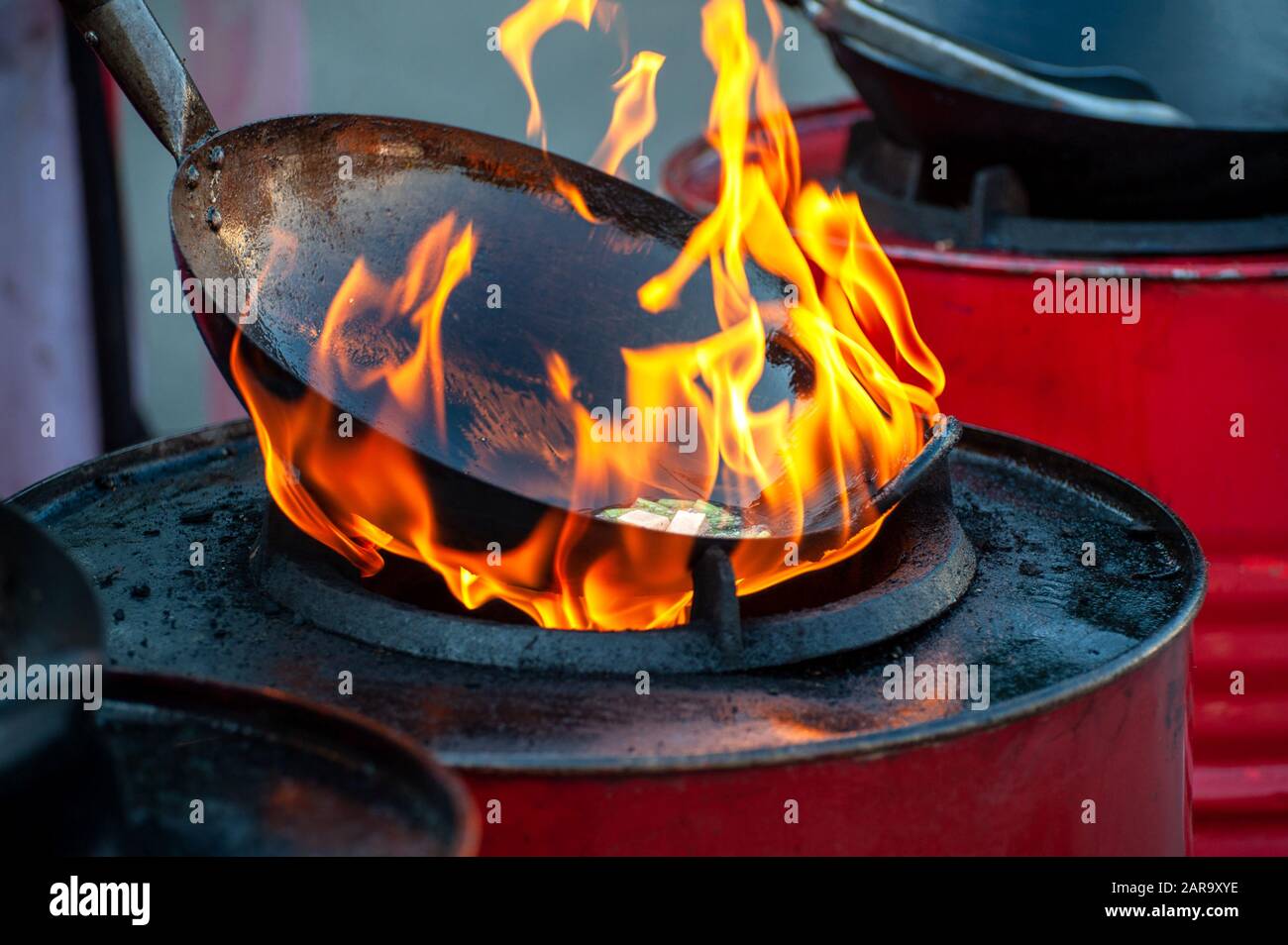 Chef cooking with fire in frying pan on street Stock Photo - Alamy