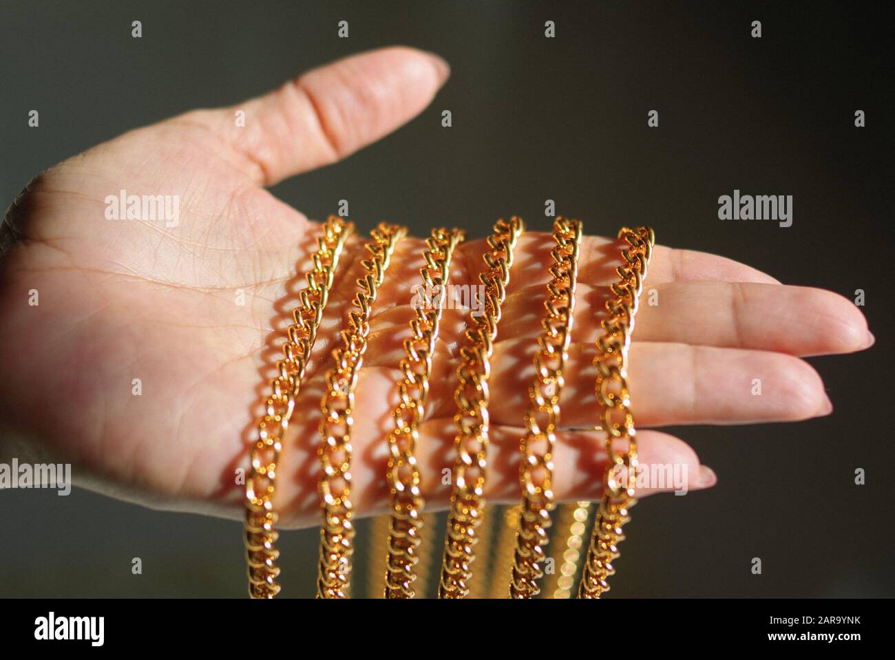 The gold chain in the palm Stock Photo - Alamy