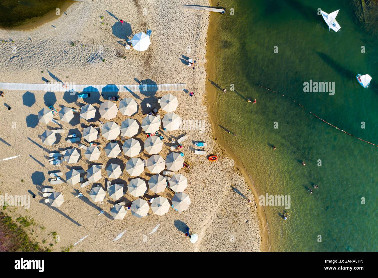 Aerial view of sandy beach with tourists swimming in beautiful clear ...