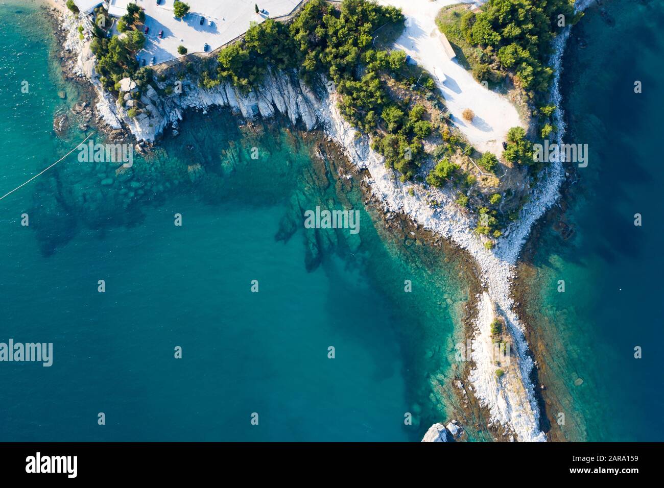 Aerial view from flying drone of a small peninsula with calm turquoise ...