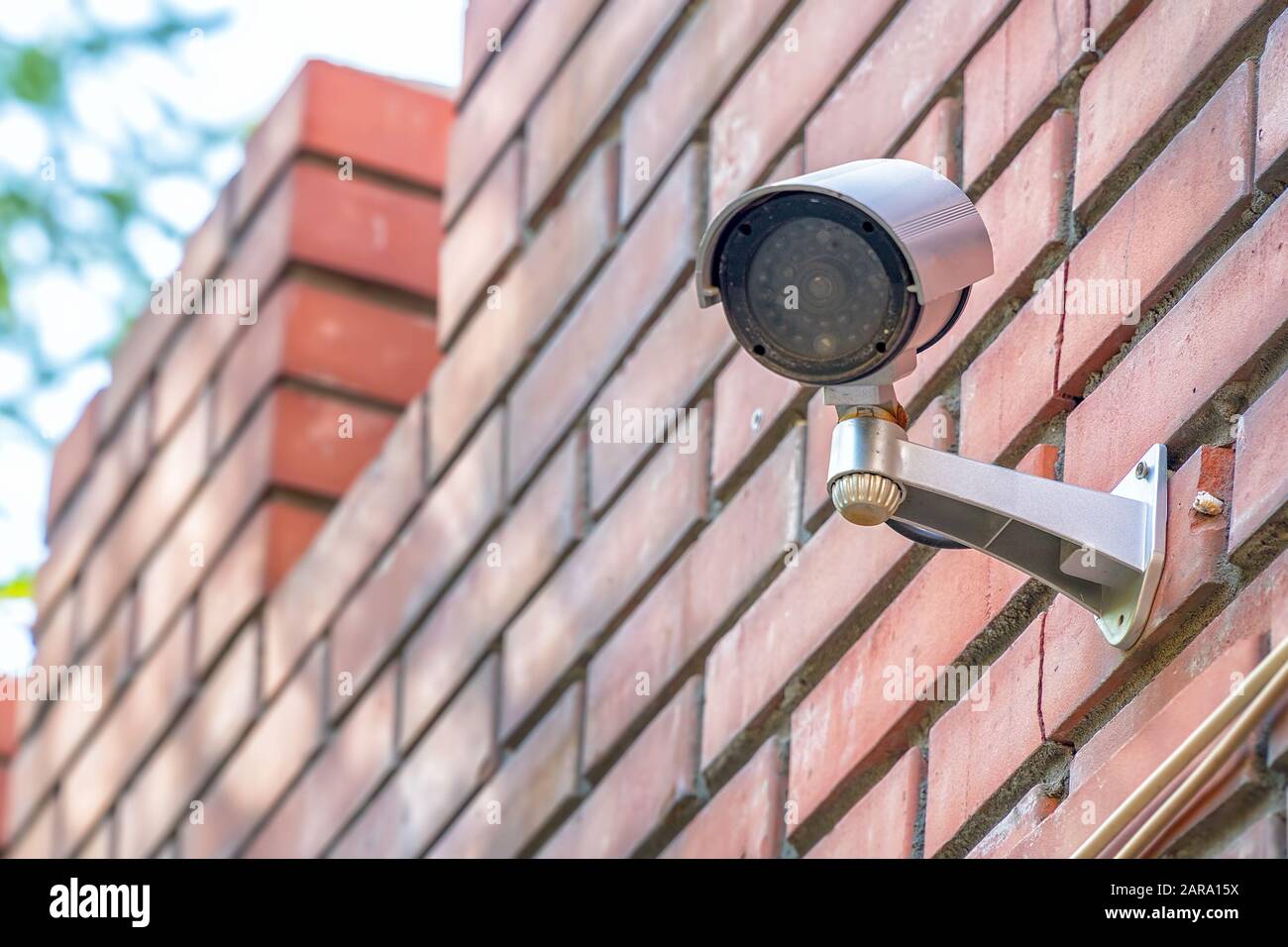 Surveillance camera on a red brick wall Stock Photo - Alamy