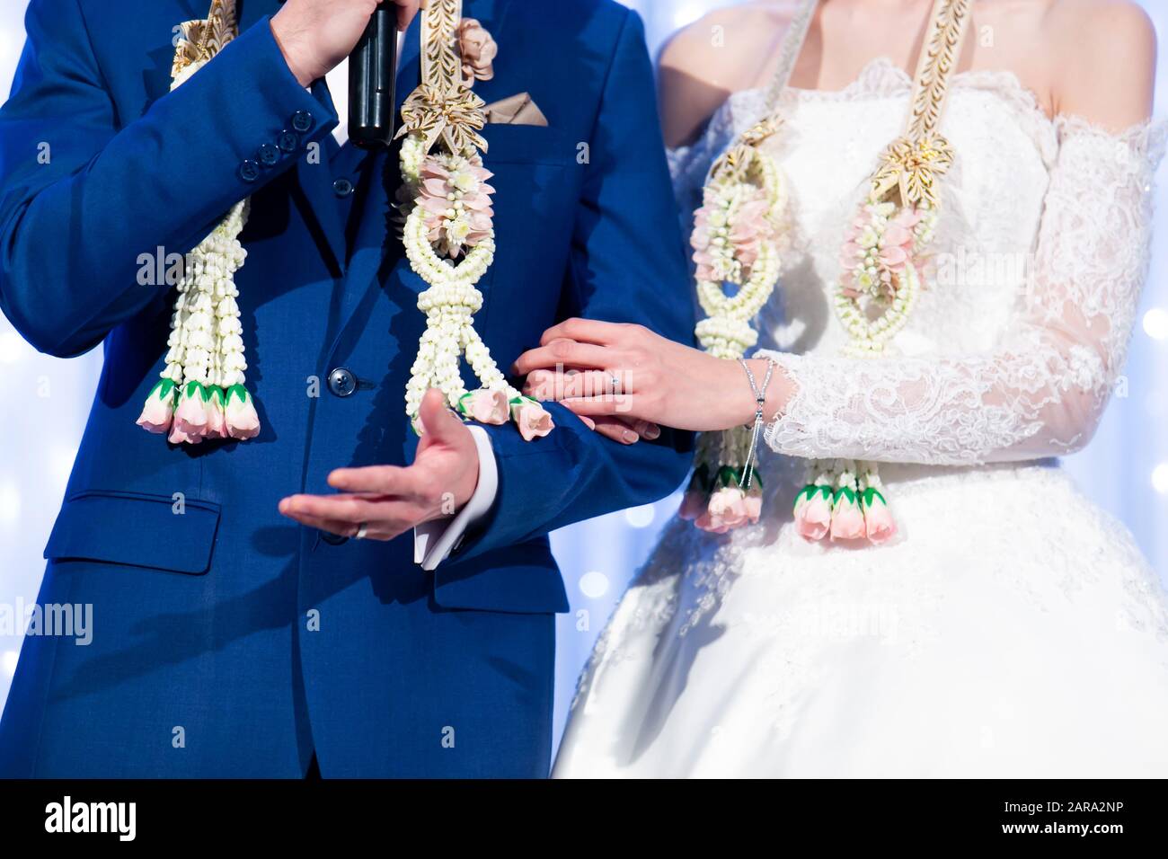 Bride and Groom in formal costumes with flower garlands, looking ...