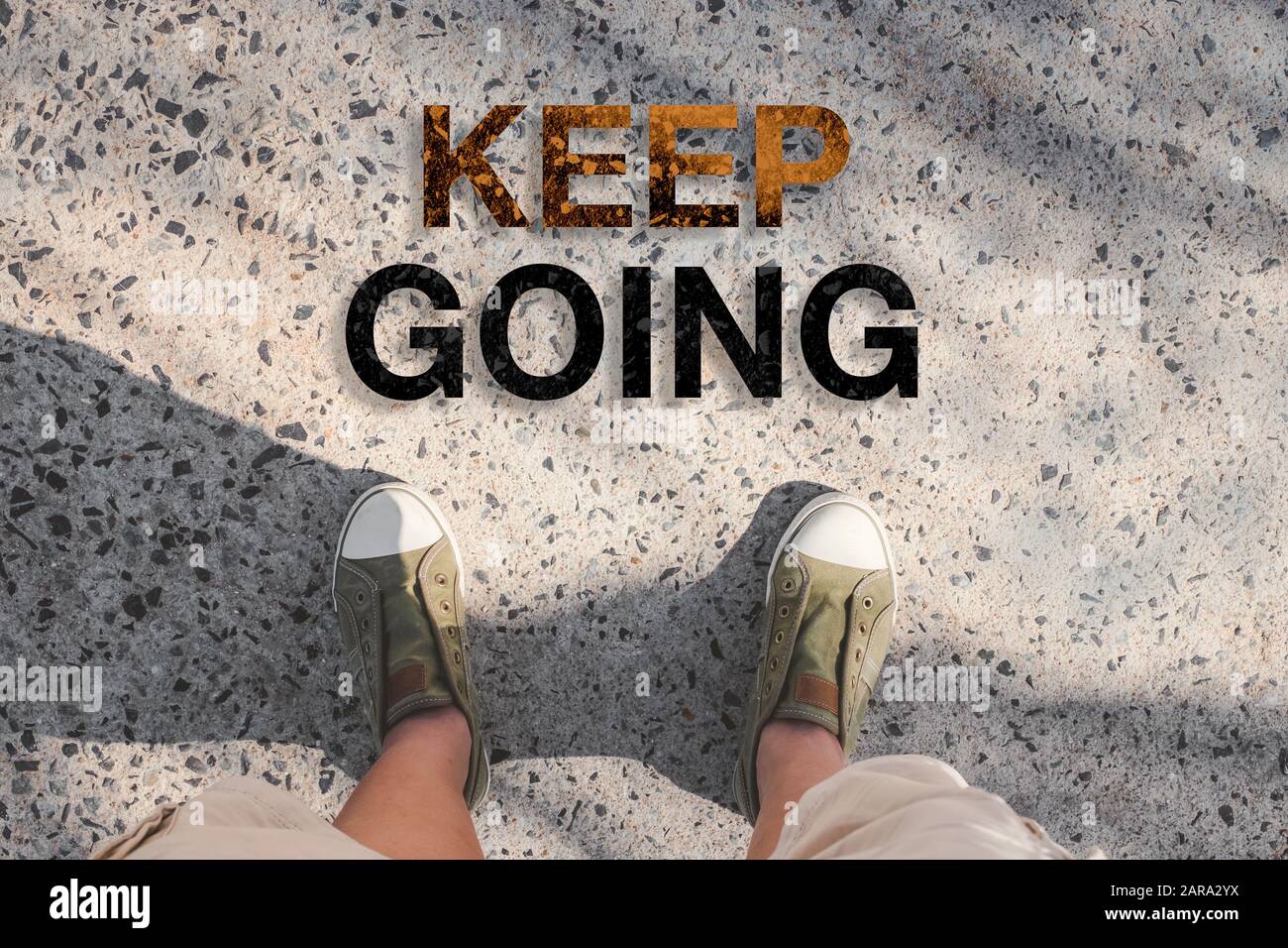 Aerial view of keep going word on stone floor with people foot wear ...