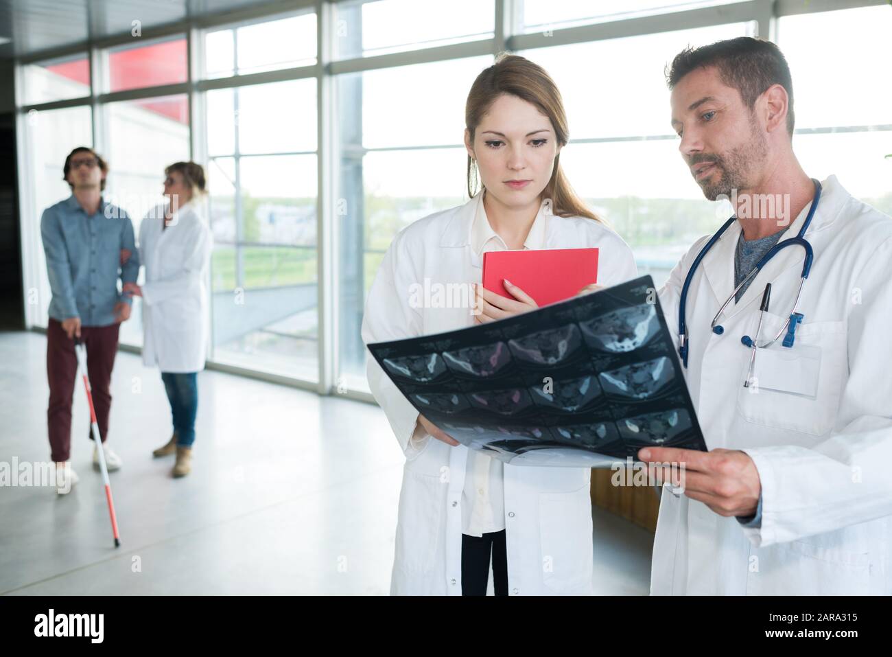 doctors discussing diagnosis in hospital lobby Stock Photo - Alamy