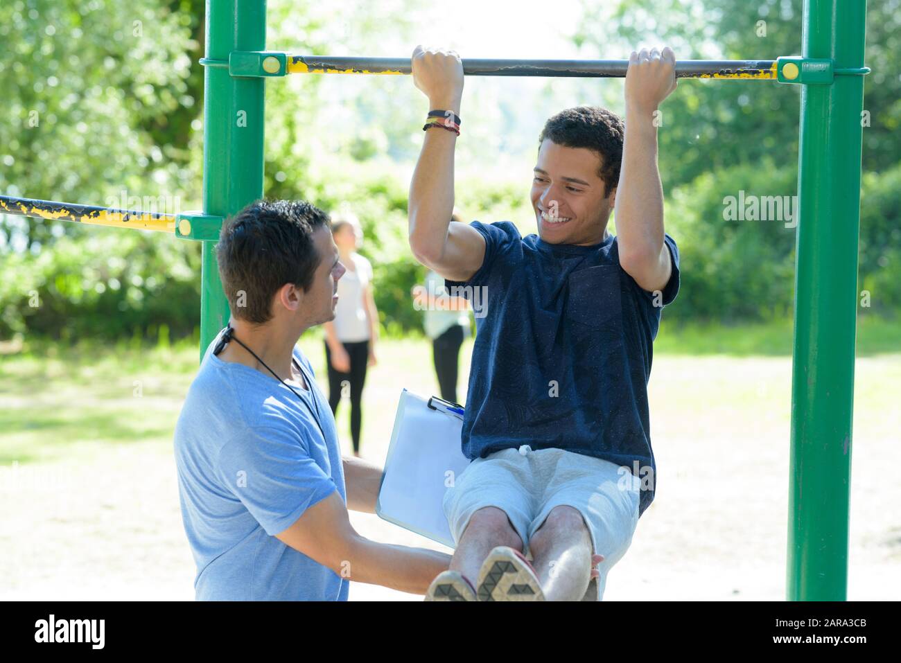 young man in training on monkey bars lifting his legs Stock Photo - Alamy