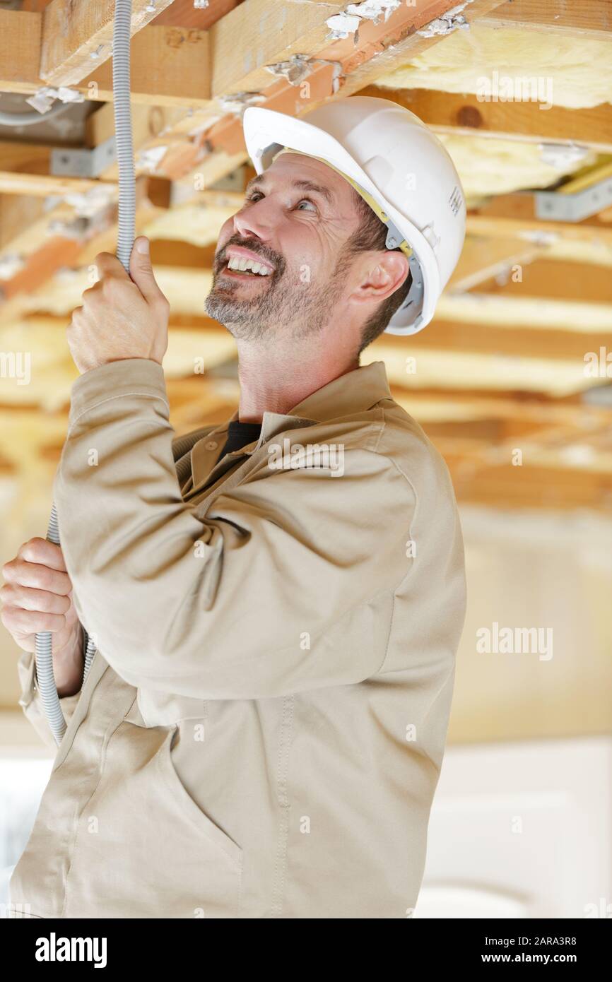 construction worker fixing cable in the ceiling Stock Photo - Alamy