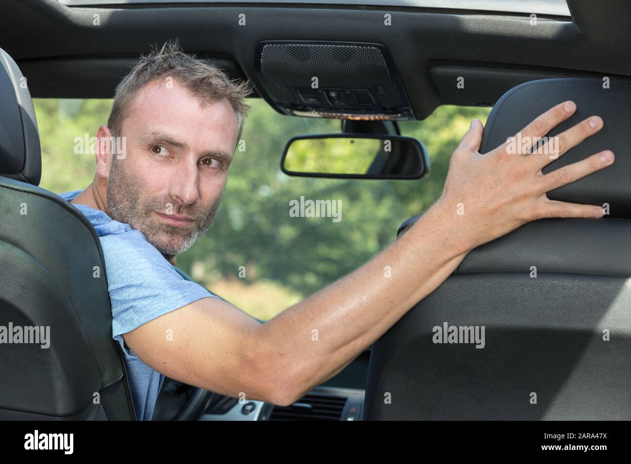 mature professional man driving a car in reverse Stock Photo - Alamy