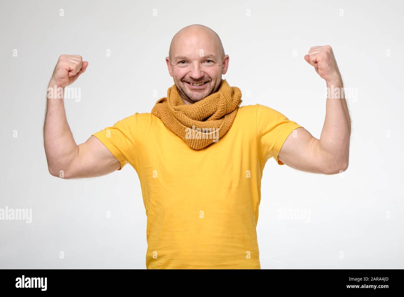 Strong, positive man in a bright yellow t-shirt and scarf, bent his ...