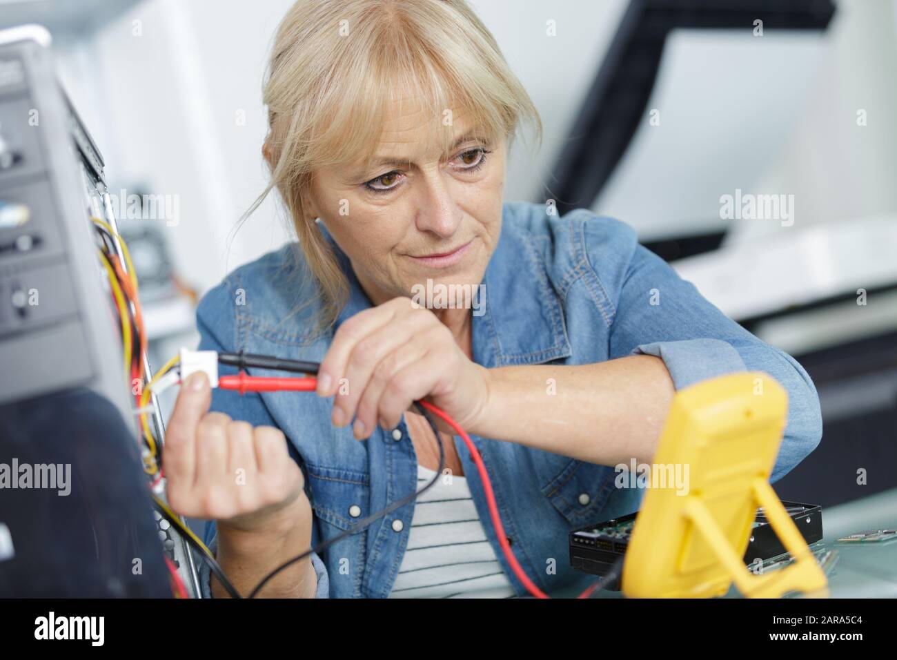 an elderly woman fixing a pc Stock Photo - Alamy