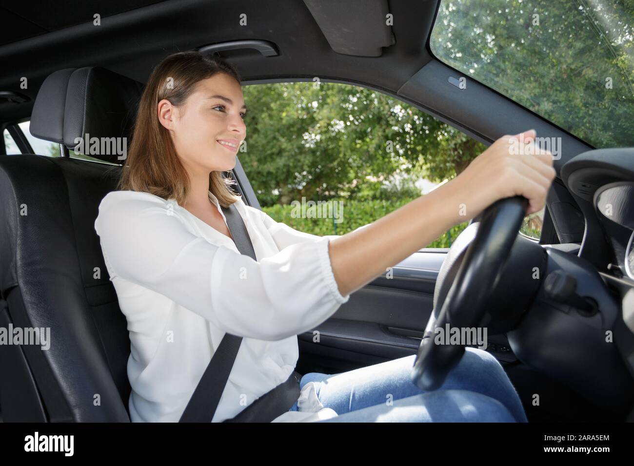 a happy female driver smiling Stock Photo - Alamy