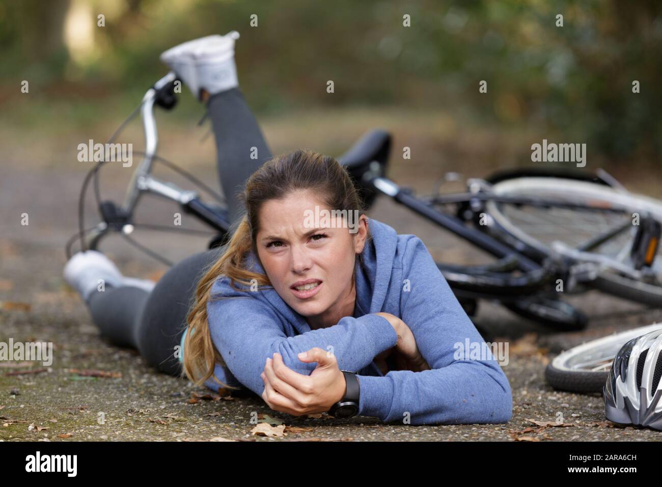 young woman fallen from bicycle and holding her elbow Stock Photo - Alamy