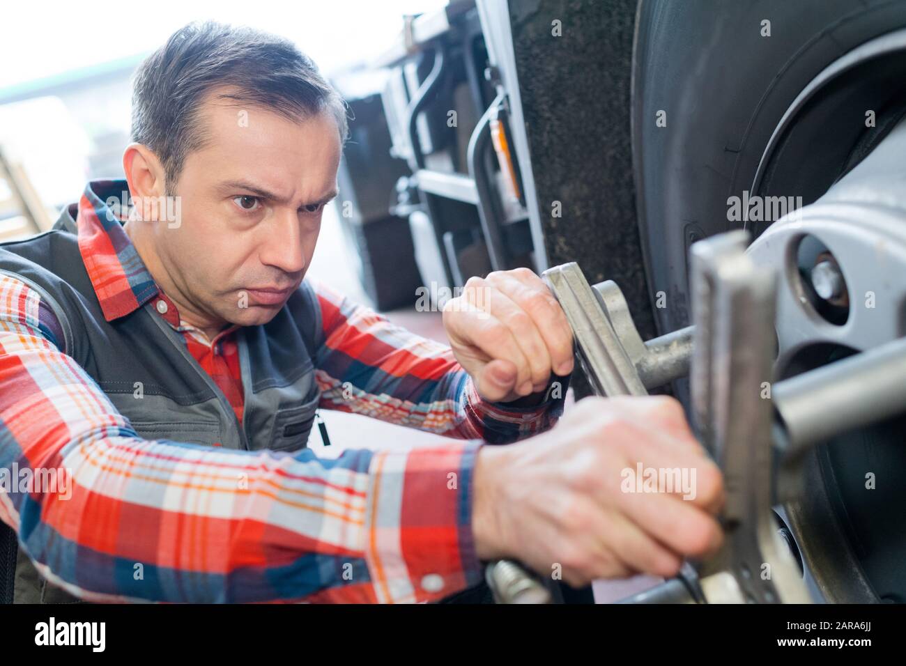 mechanic working on the wheel of a heavy goods vehicle Stock Photo - Alamy