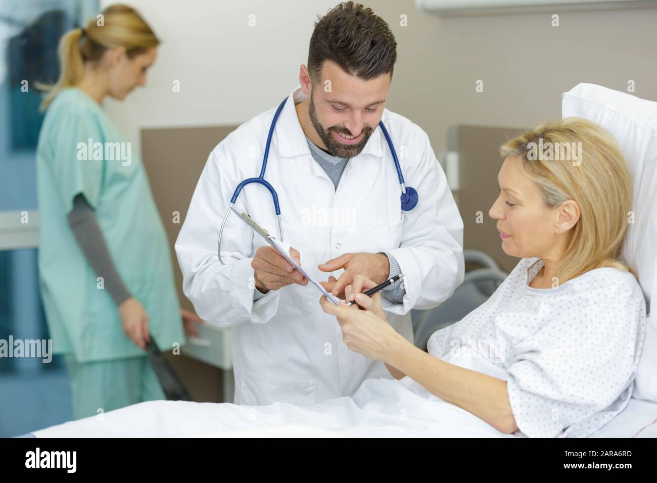 patient in hospital bed signing consent form Stock Photo - Alamy