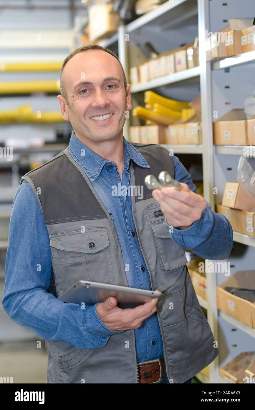 standing worker holding digital tablet in warehouse Stock Photo - Alamy