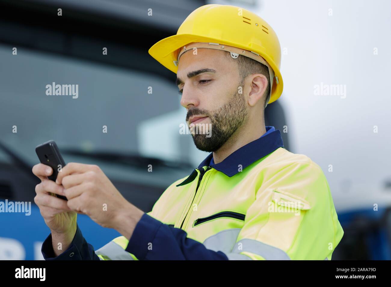 worker sending a message on his cellphone Stock Photo - Alamy