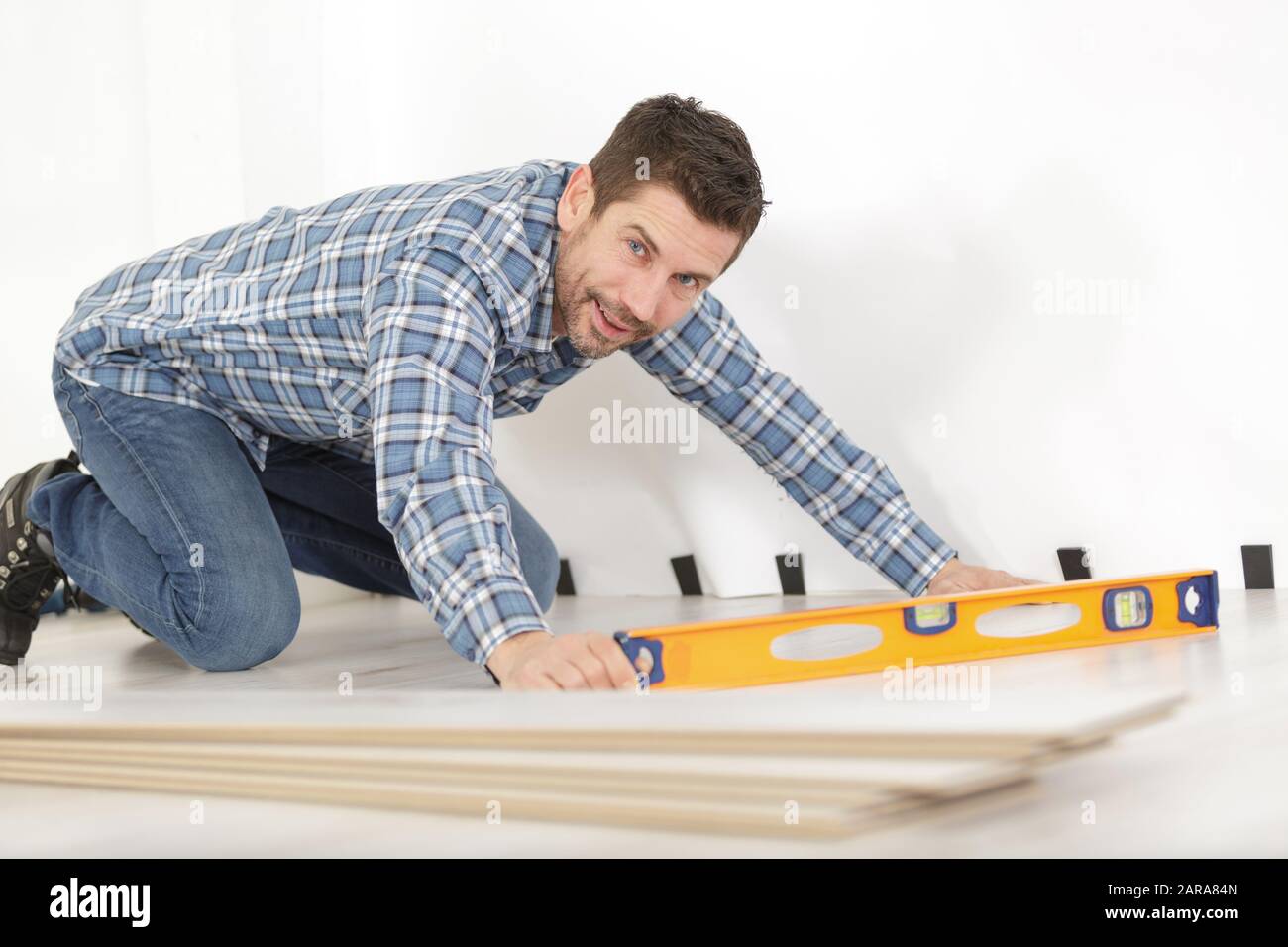 man measuring wood piece for furniture assembling Stock Photo - Alamy
