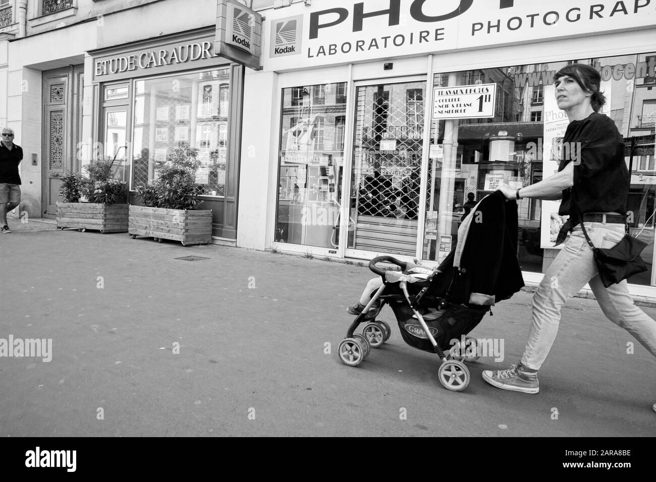 Woman walking pushing pram on pavement, Photo Center, Rue Saint Antoine ...