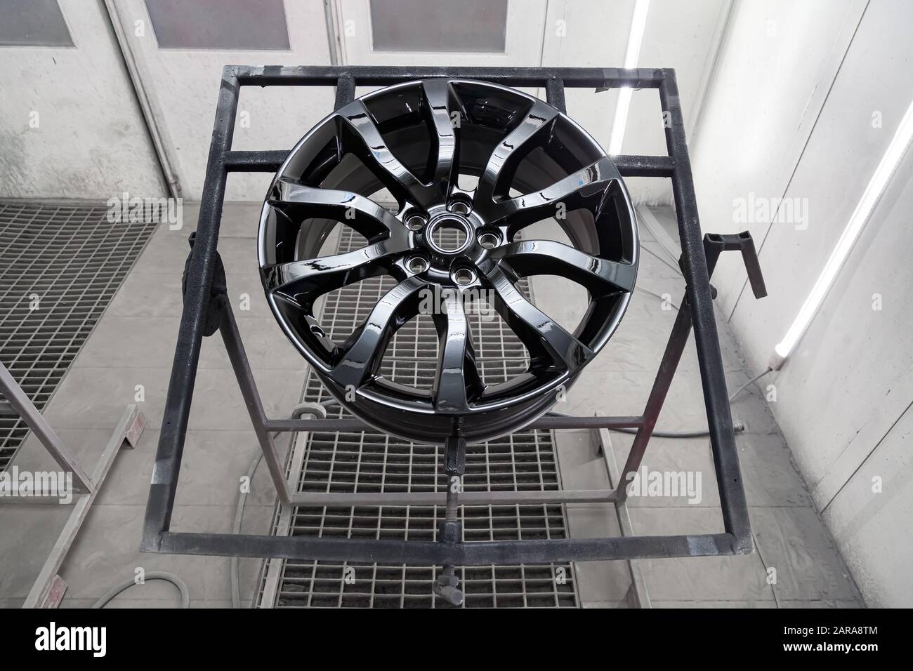 A black painted aluminum alloy wheel is mounted on a special frame ...