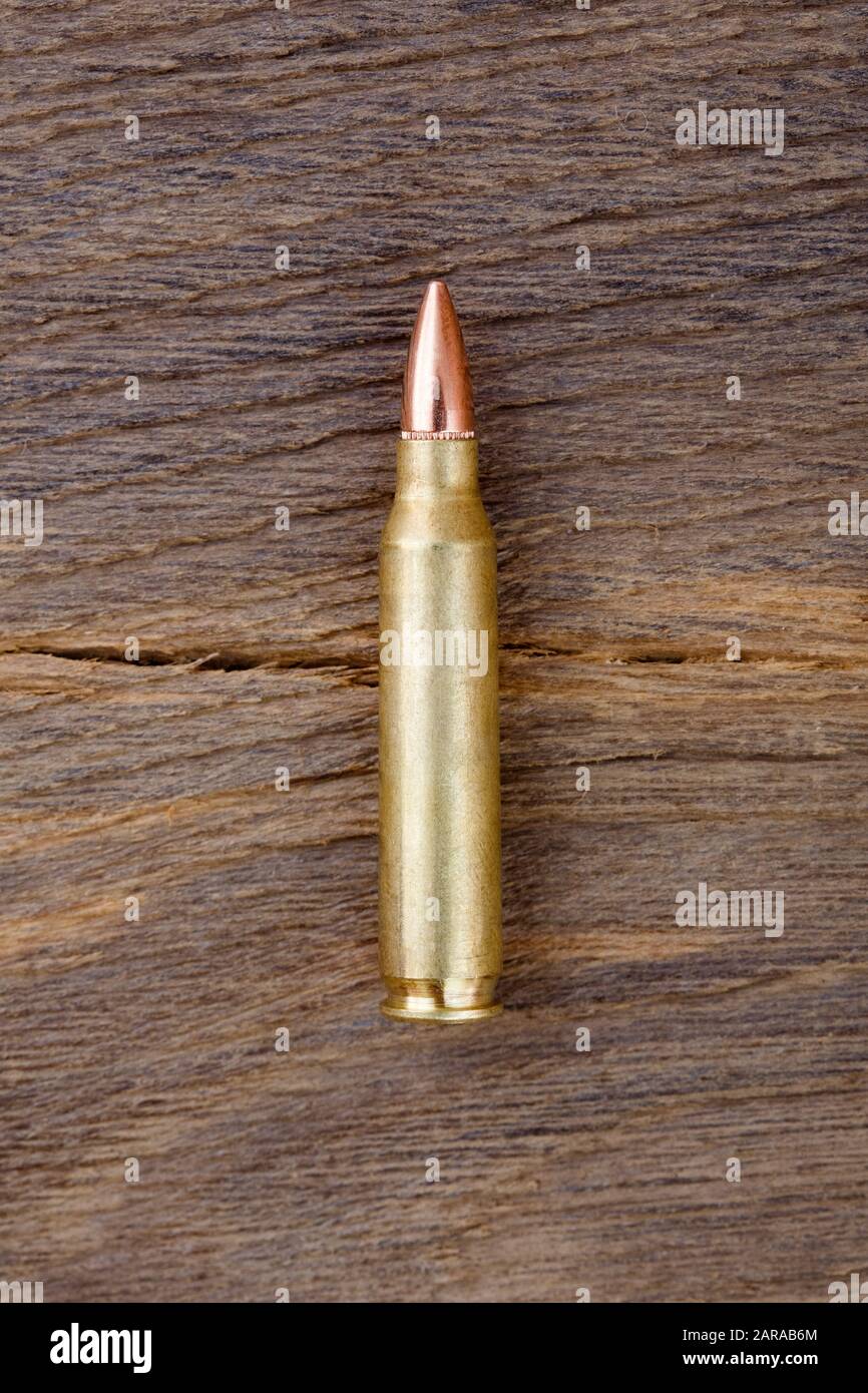 Close-up of rifle bulet on old wood desk background Stock Photo - Alamy