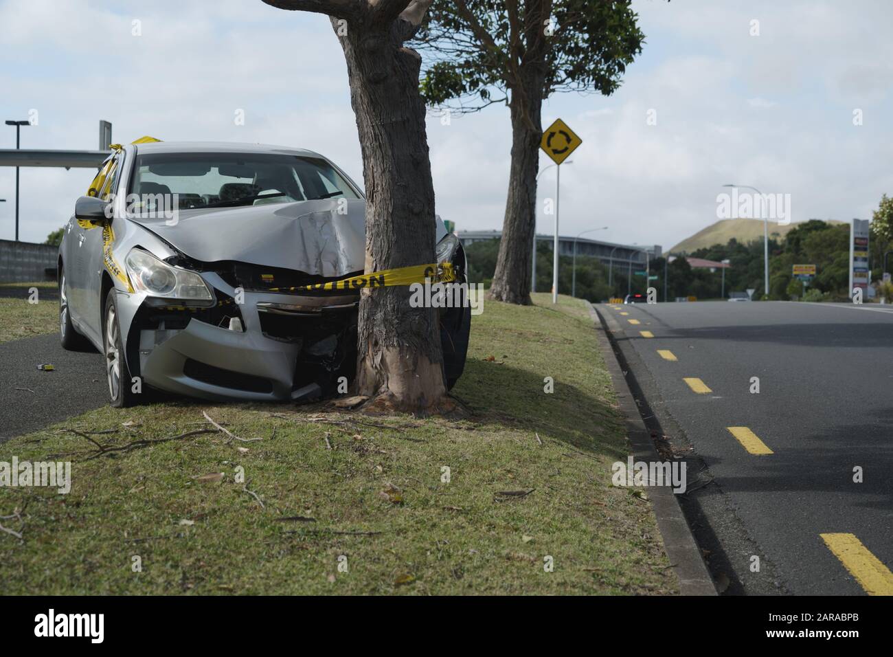 Silver sedan car mounted pavement crash crashed head on into tree ...