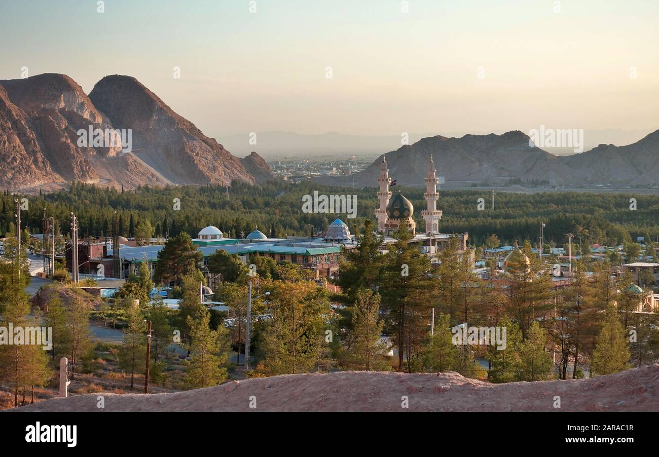 Saheb Zaman Mosque cemetery behind desert mountains and forest, Kerman ...