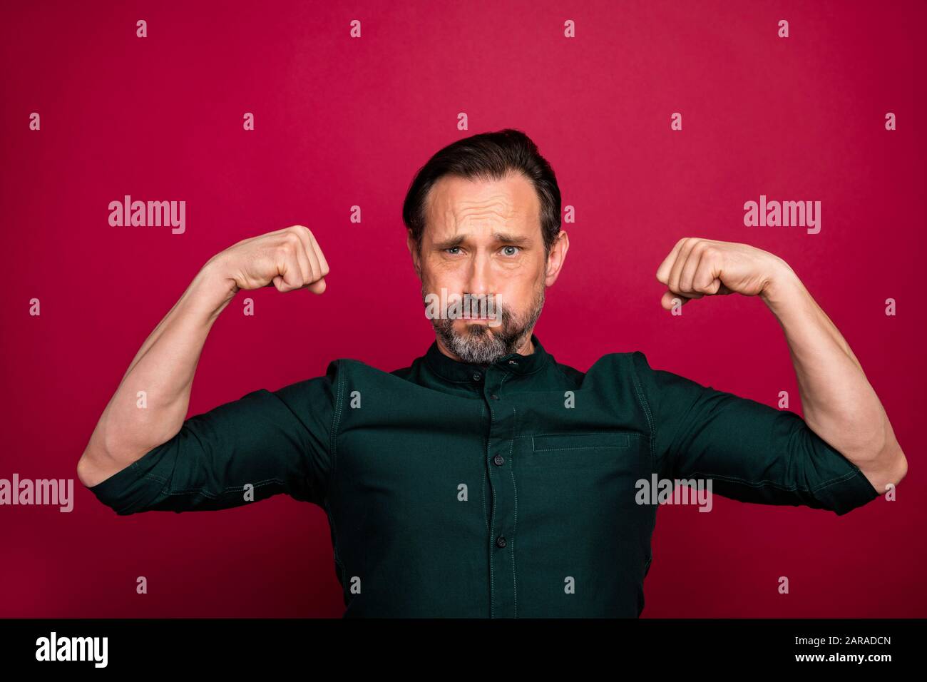 Photo of funny man pretending to be strong after day in gym showing his ...