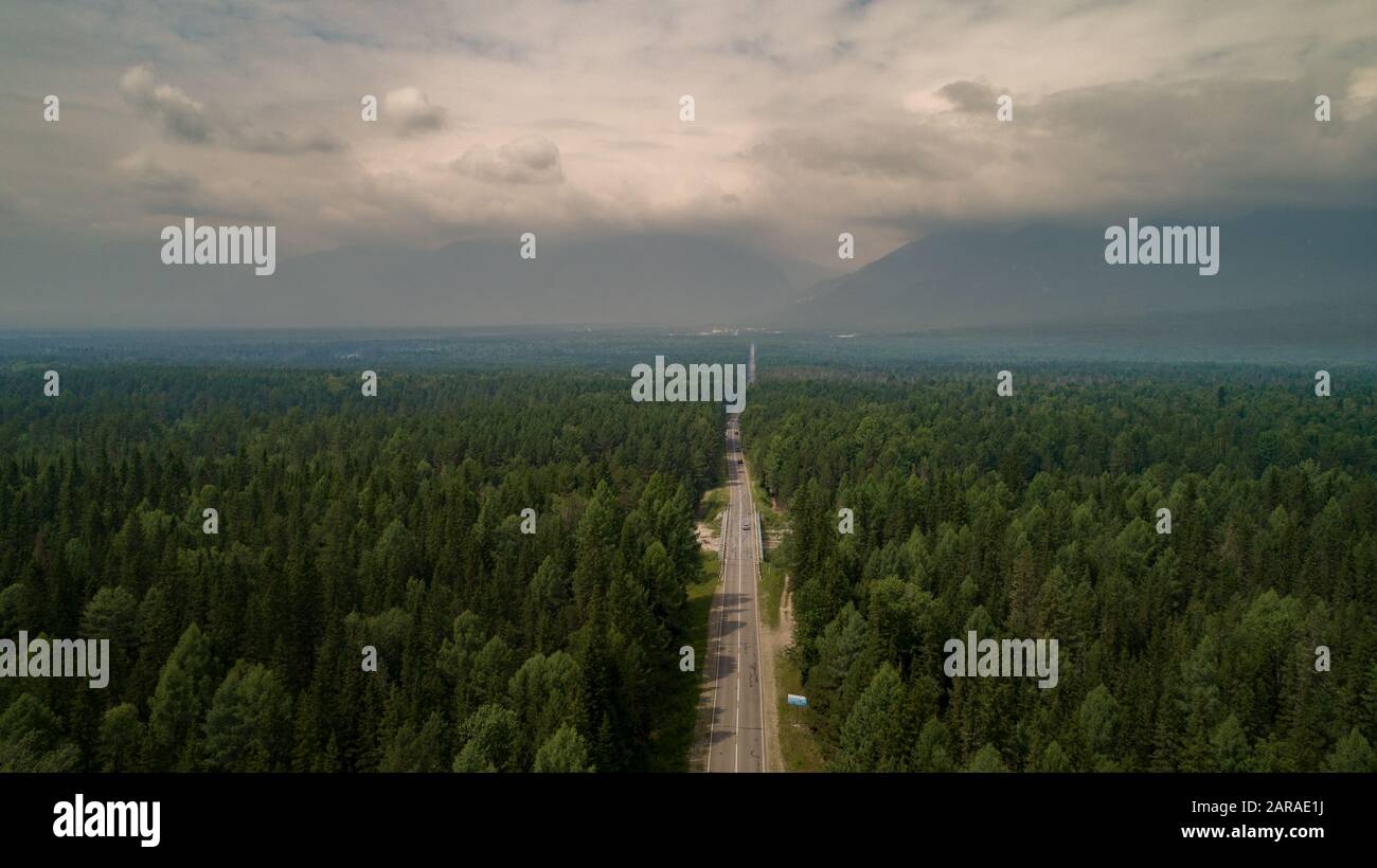 Aerial view of white car driving on country road in forest. Cinematic ...