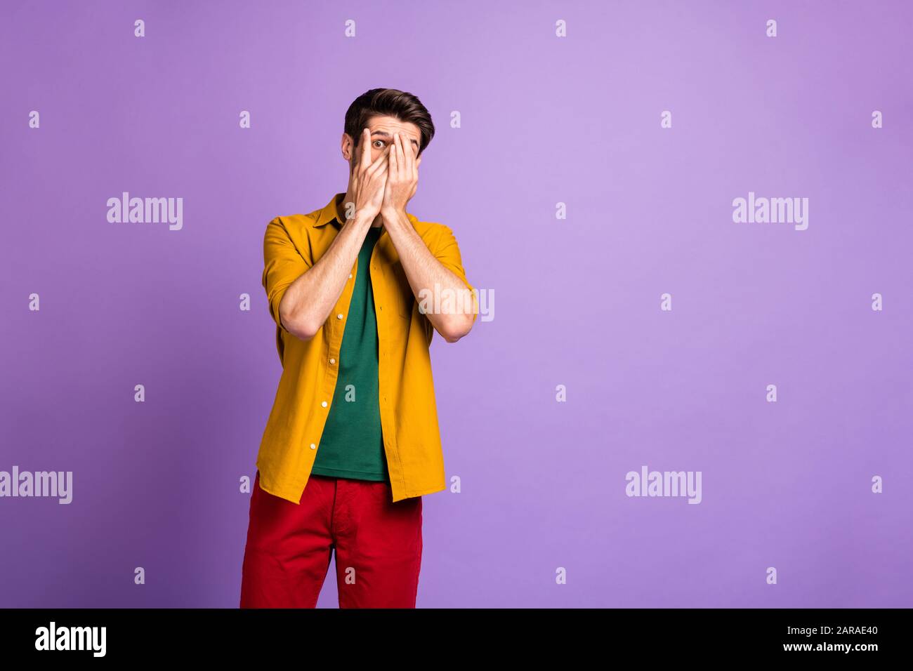 Portrait of horrified terrified guy close cover eyes watch horror movie ...