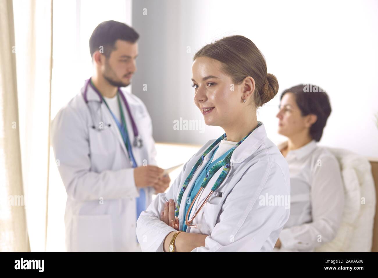 Patient with a group of doctors at the background Stock Photo - Alamy