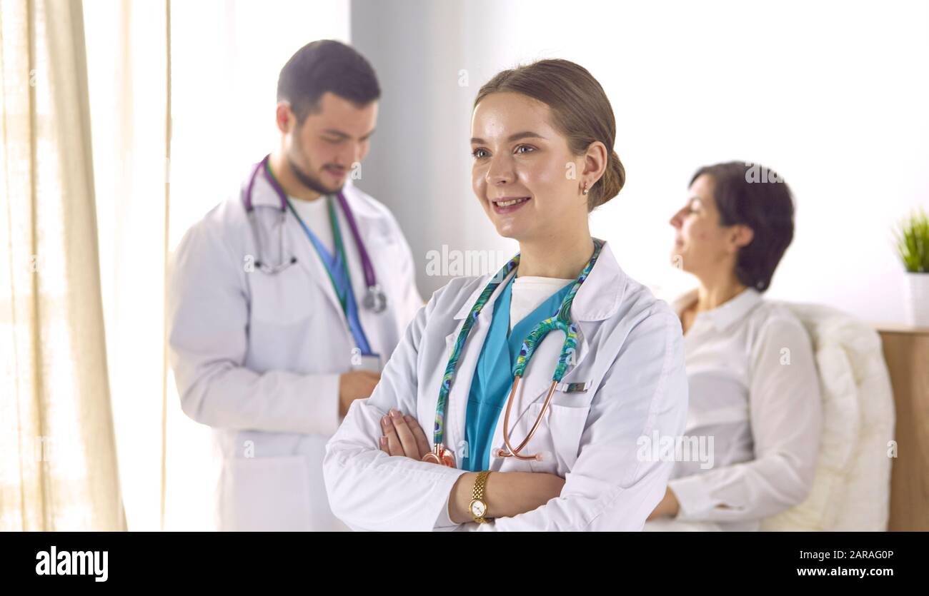 Patient with a group of doctors at the background Stock Photo - Alamy