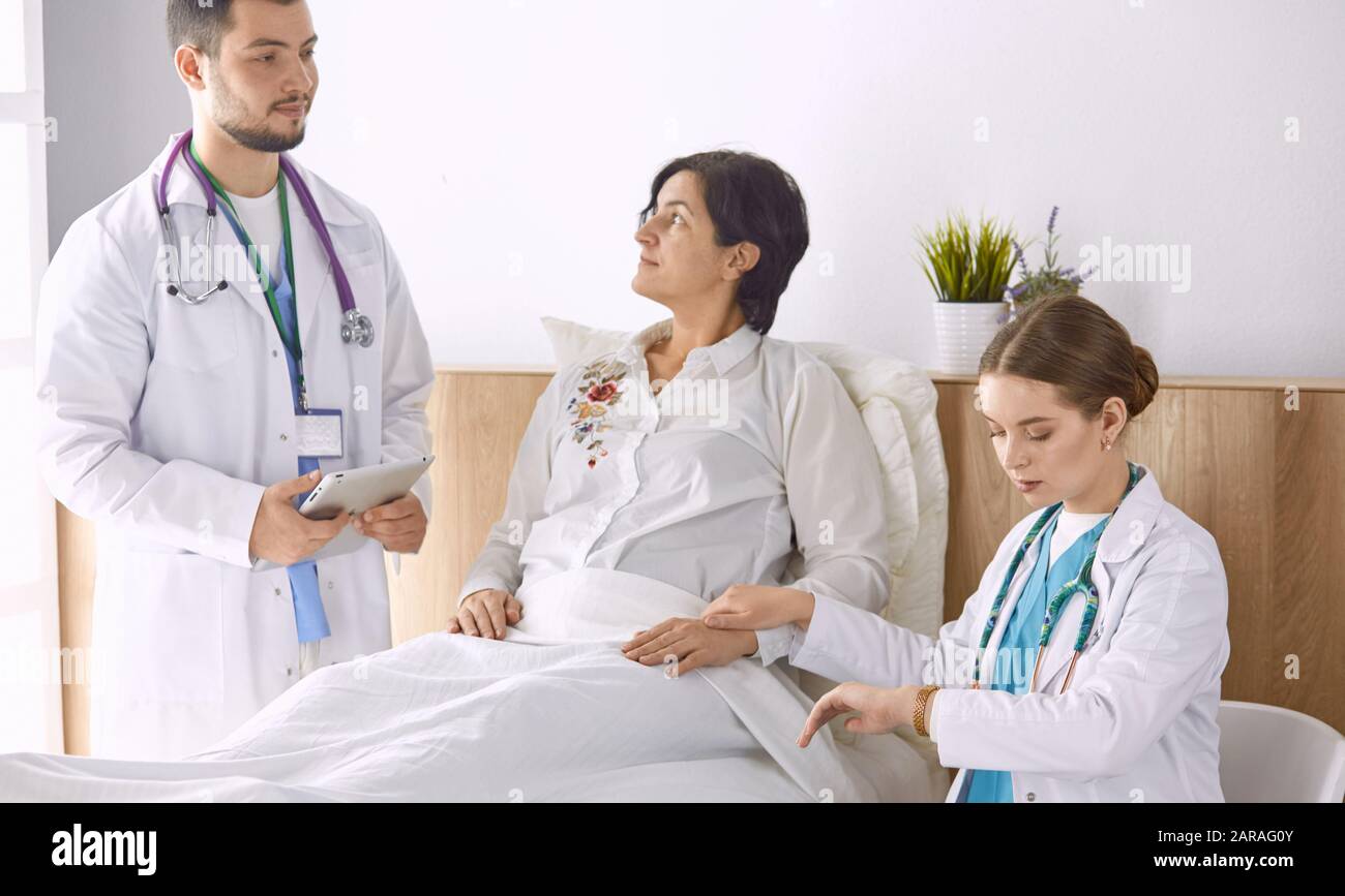 Patient with a group of doctors at the background Stock Photo - Alamy