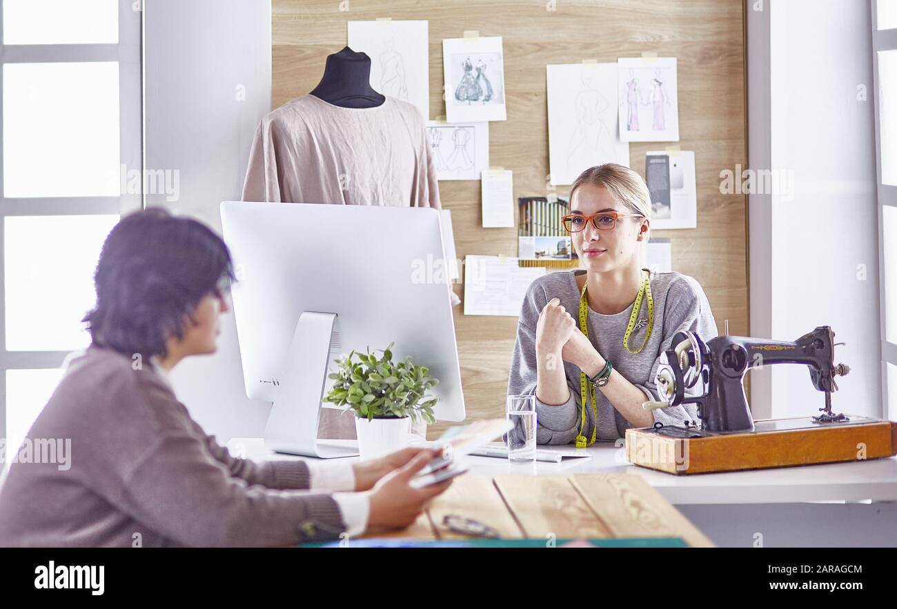 pretty dressmaker showing a new design to her client Stock Photo - Alamy