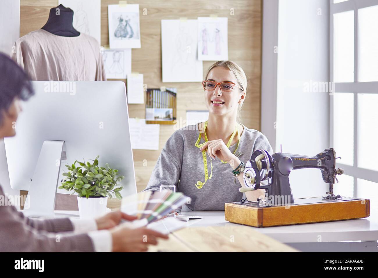 pretty dressmaker showing a new design to her client Stock Photo - Alamy