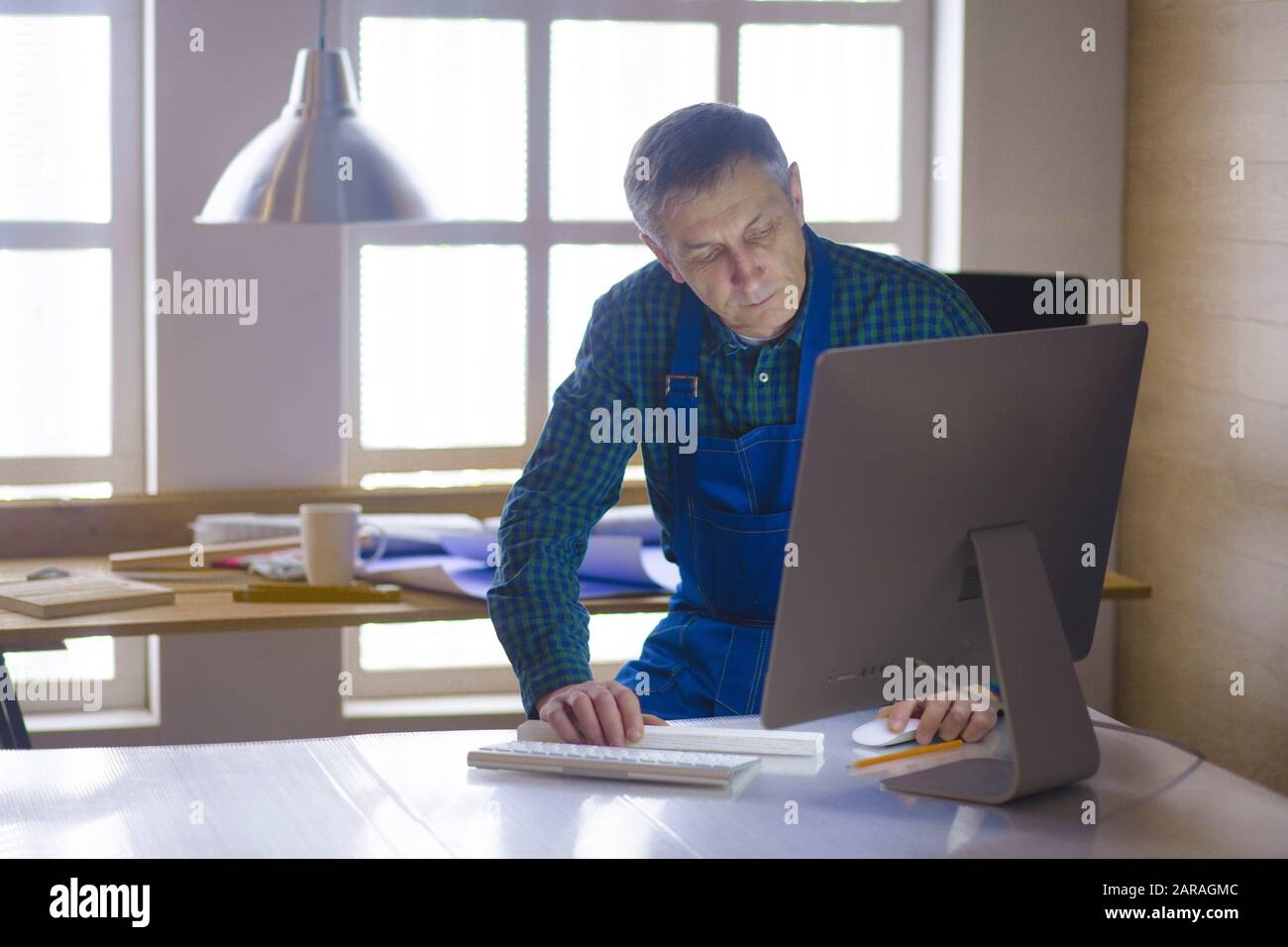 Engineer carpenter working on laptop and sketching project Stock Photo ...