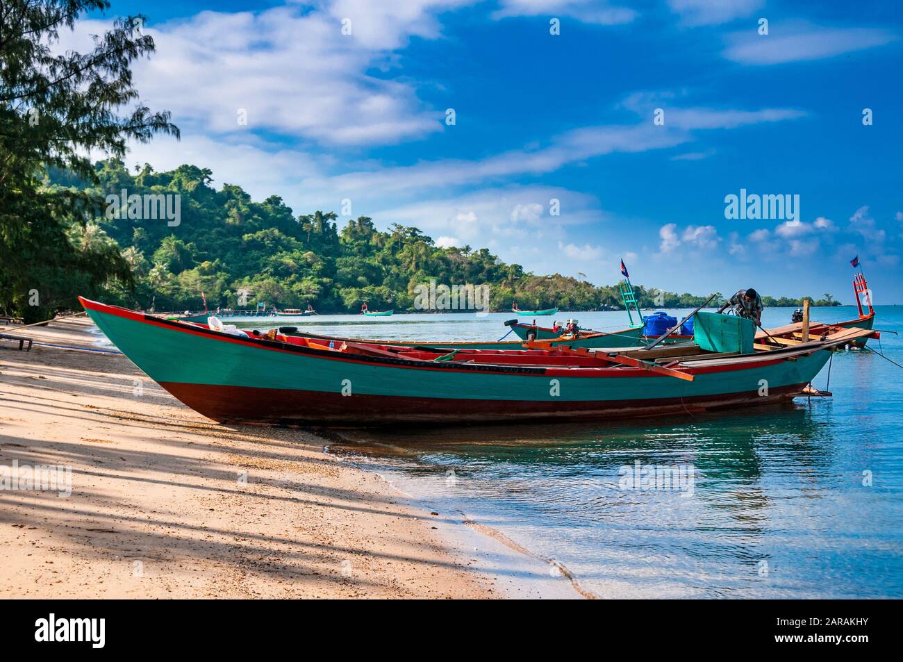A boatman tends to his vessel moored on the main tourist beach of Koh ...