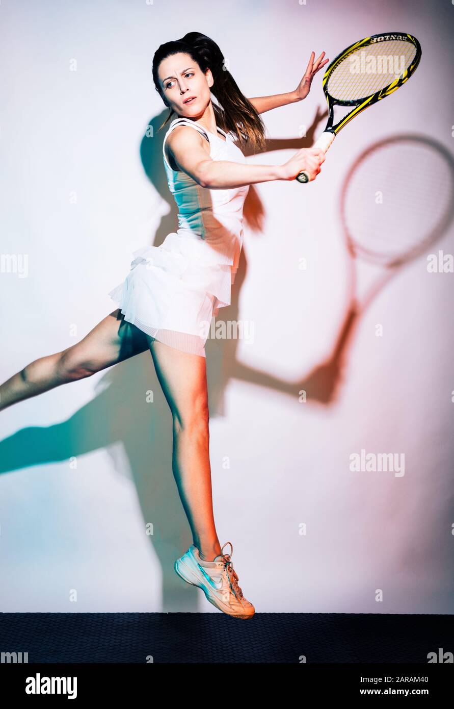 Woman practicing tennis in studio Stock Photo - Alamy