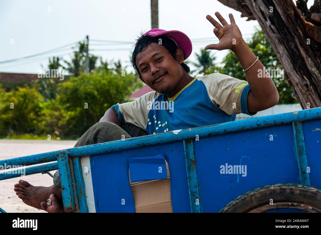 A young man relaxes in a cart whiling away the day by the river in ...