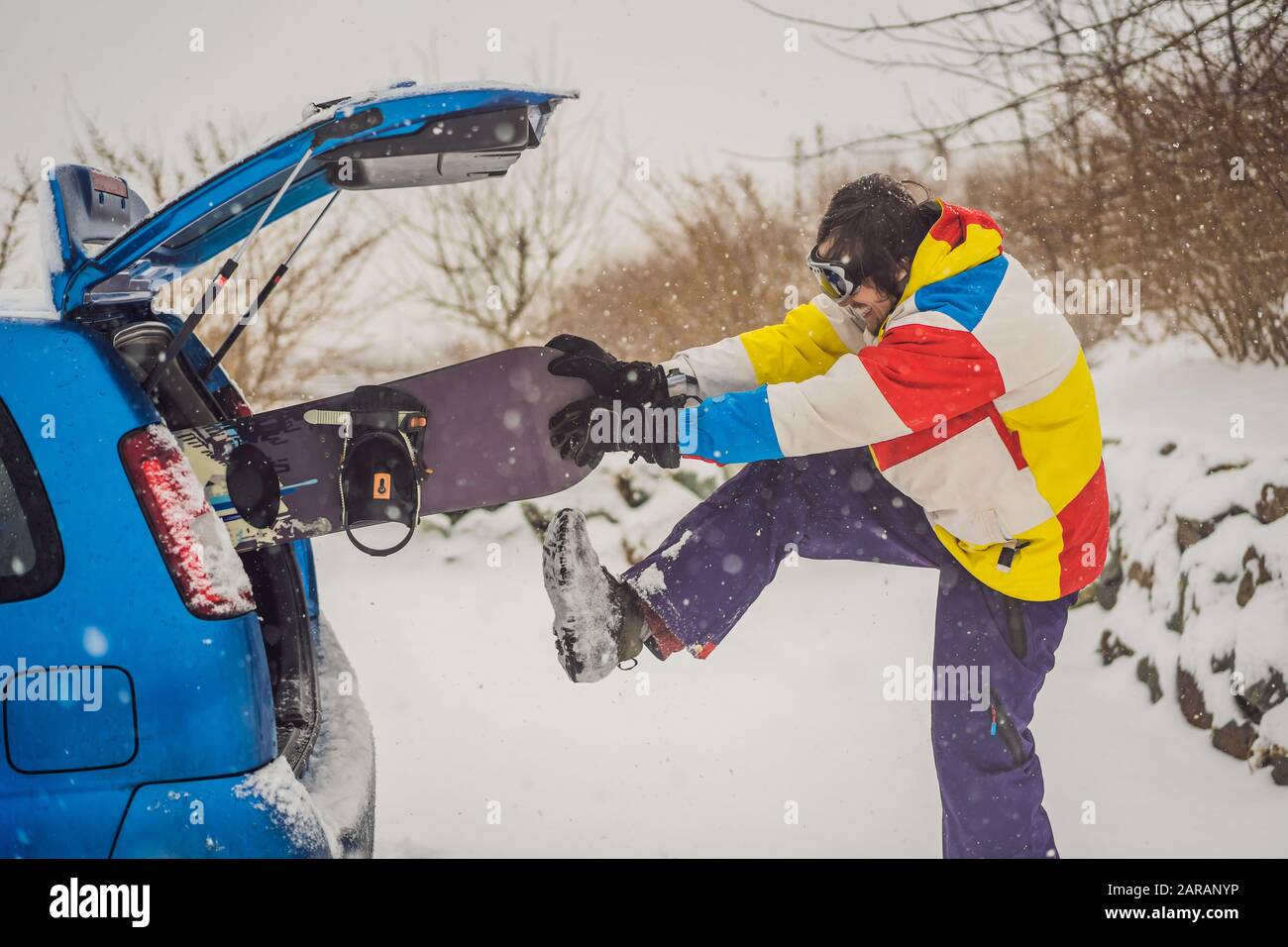 The snowboard does not fit into the car. A snowboarder is trying to ...