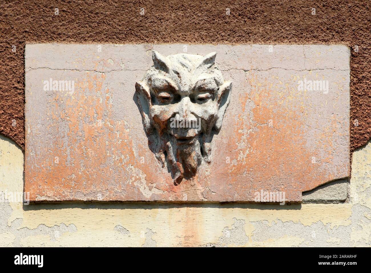 Demon like vintage retro concrete statue mounted on cracked plate on ...