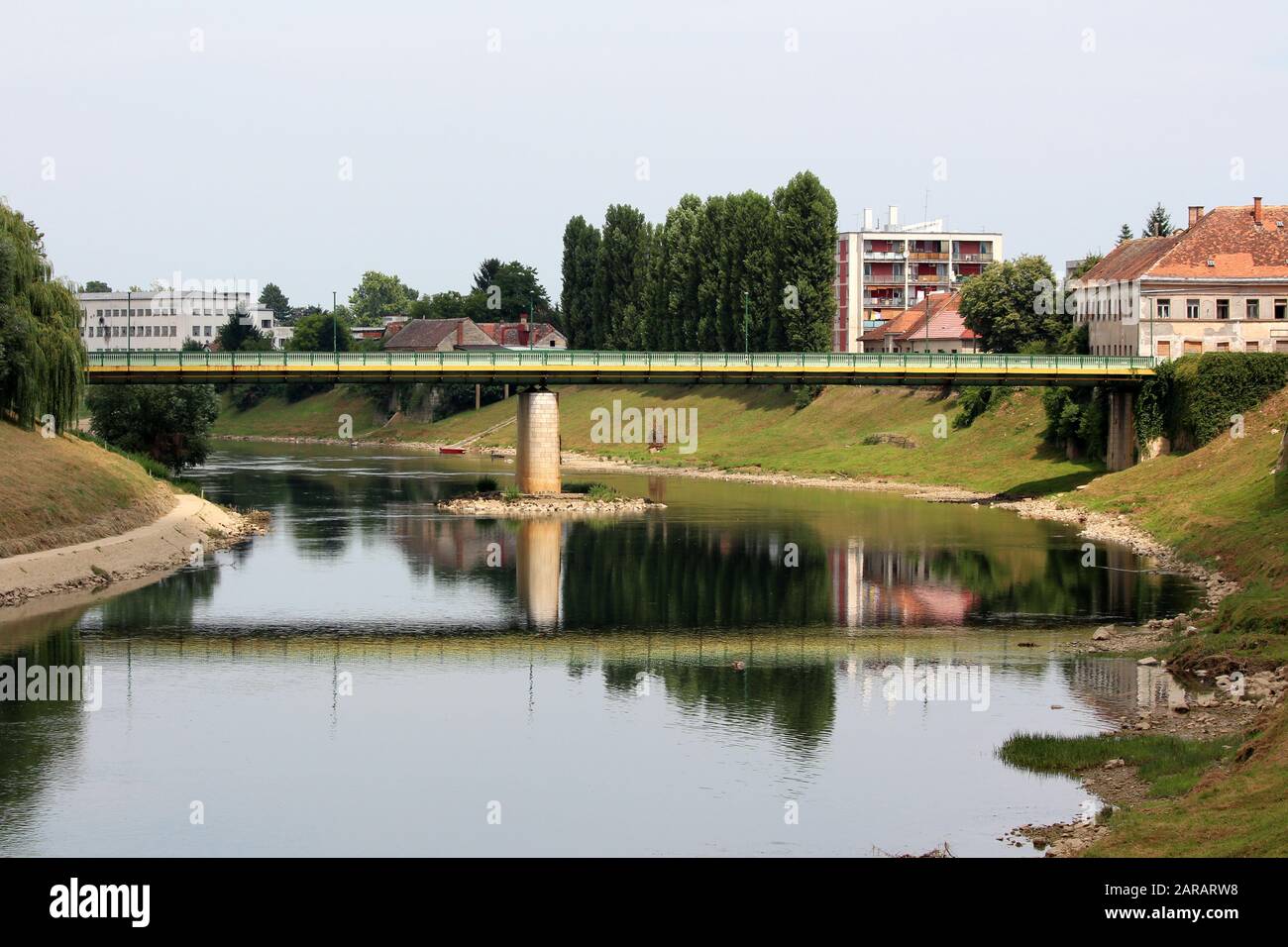 Green and yellow old metal bridge mounted on strong concrete foundation ...